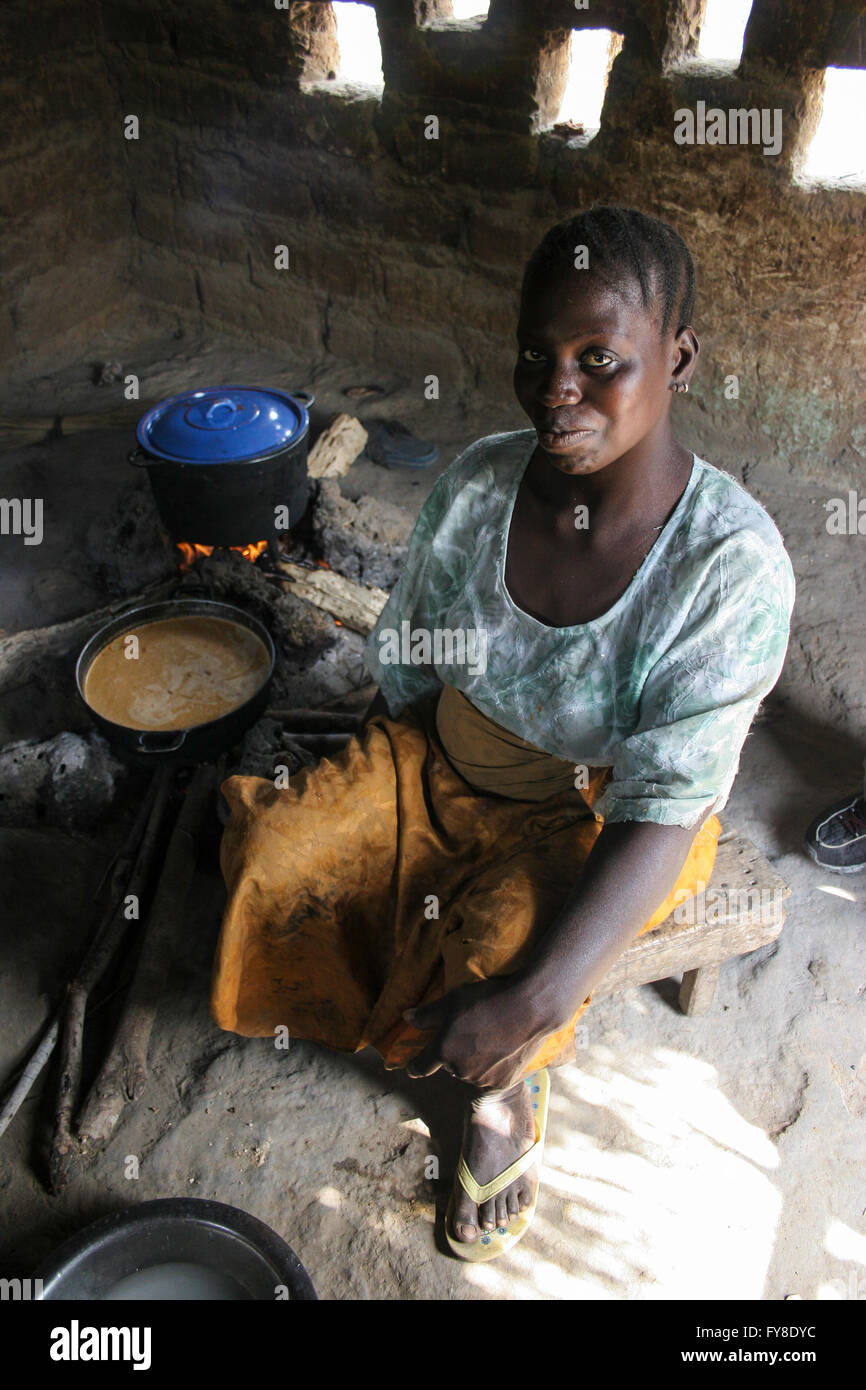 African woman cooking at the kitchen which is situated outside the ...