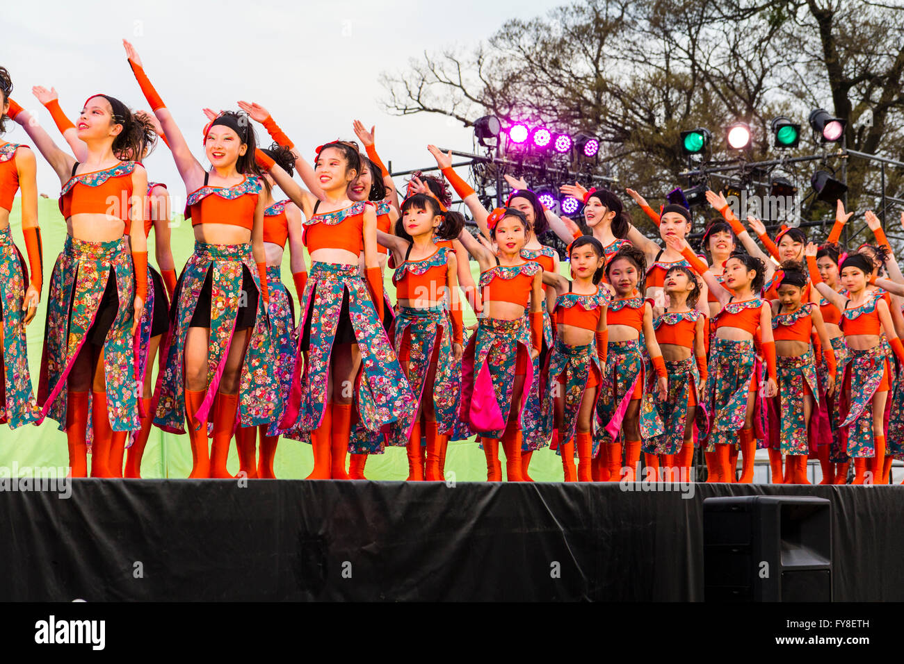 Young Japanese teenage and child dance troupe wearing orange cropped ...
