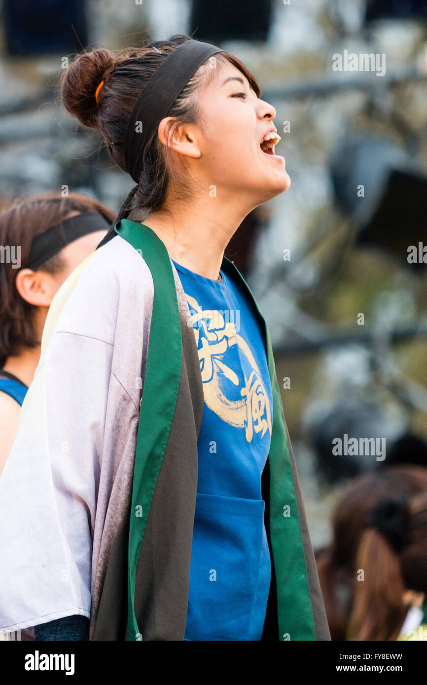 Side view of young Japanese women singing and dancing. Wears green ...
