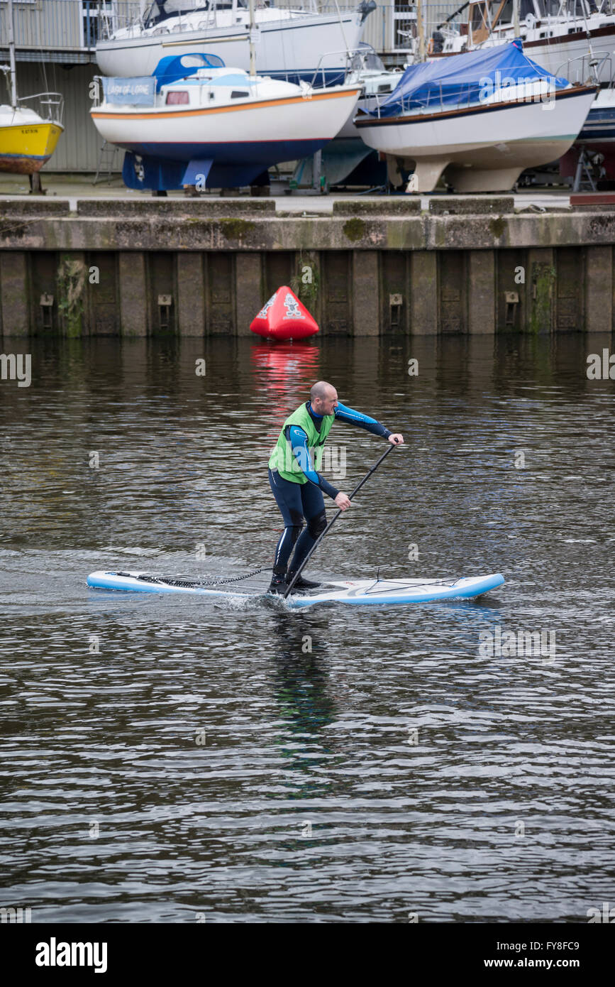Stand up paddleboarder crosses finish line in race Stock Photo - Alamy