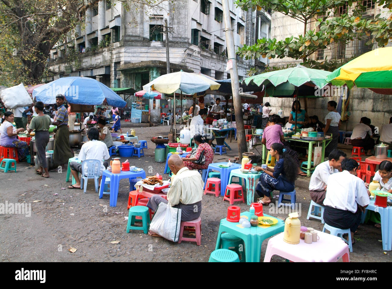 Yangon, Myanmar - 25 January 2010: People eating on small street ...