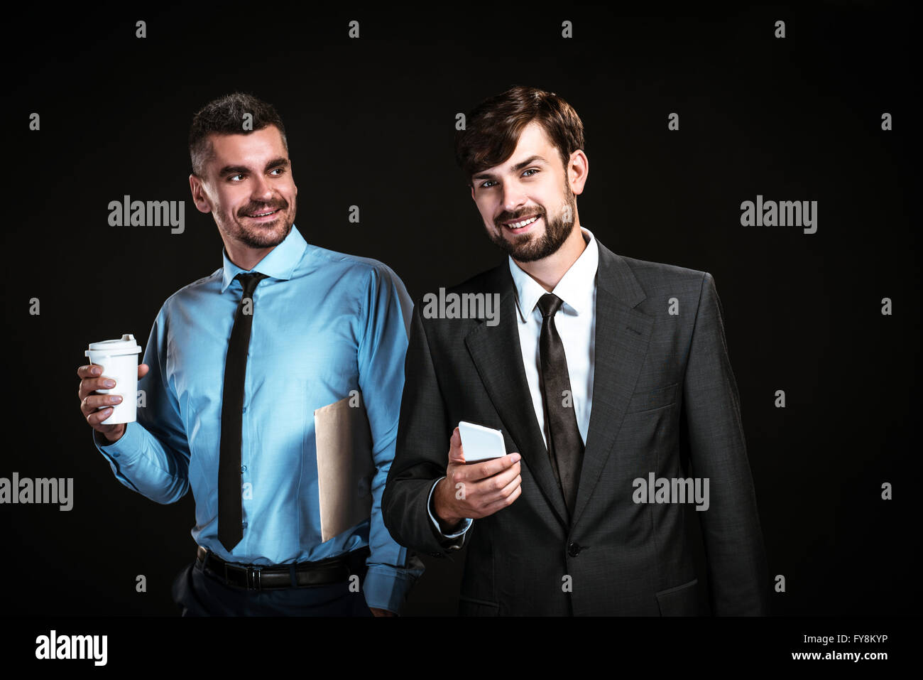 Handsome businessmen on black background Stock Photo - Alamy
