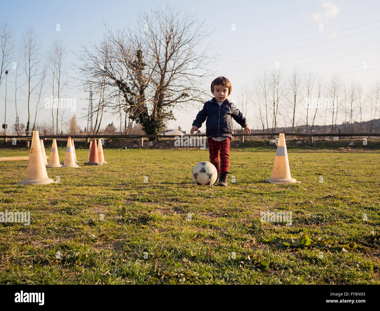 Little boy playing soccer on grass among traffic cones Stock Photo - Alamy