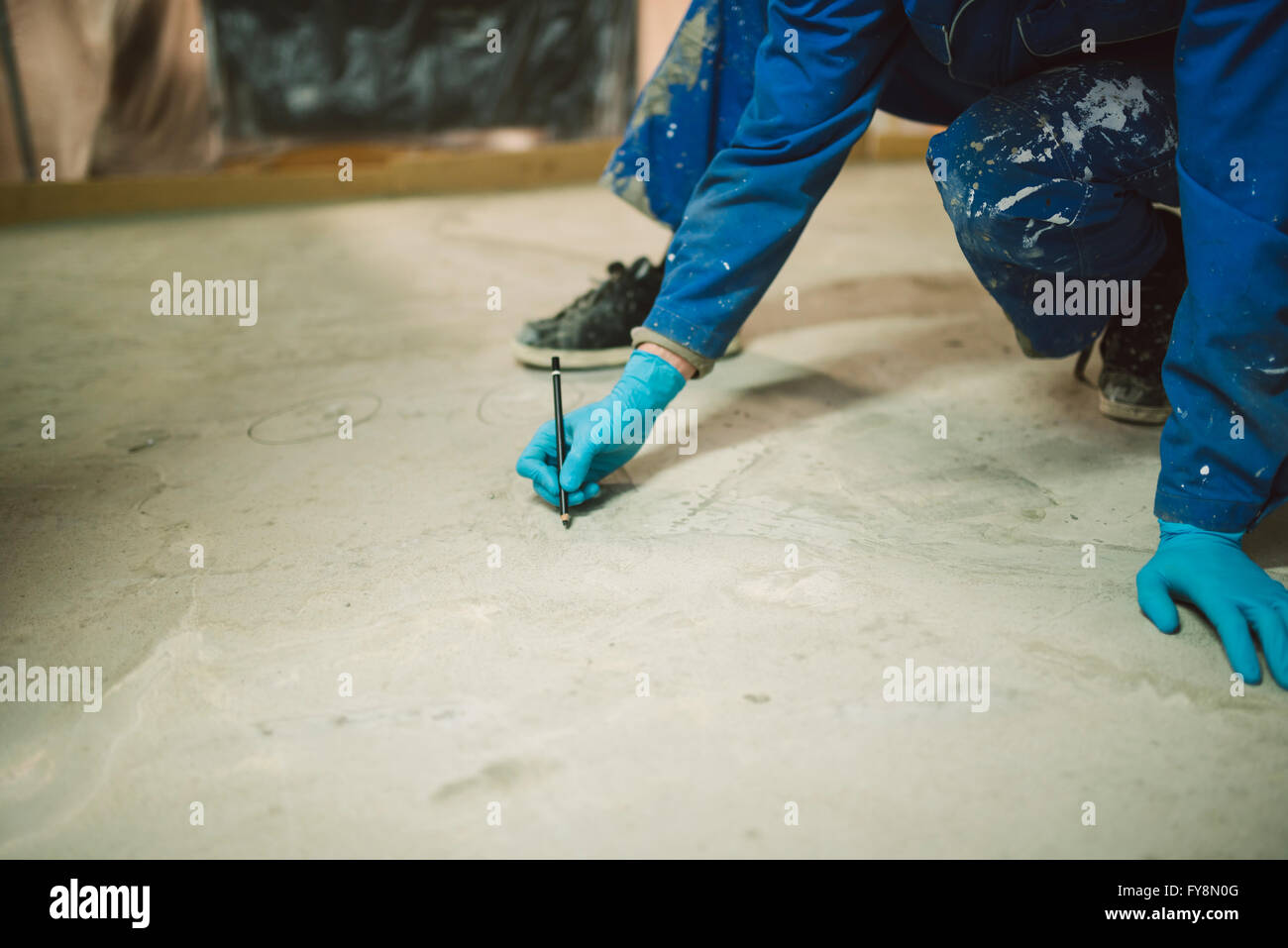 Bricklayer marking irregularities on floor screed Stock Photo - Alamy