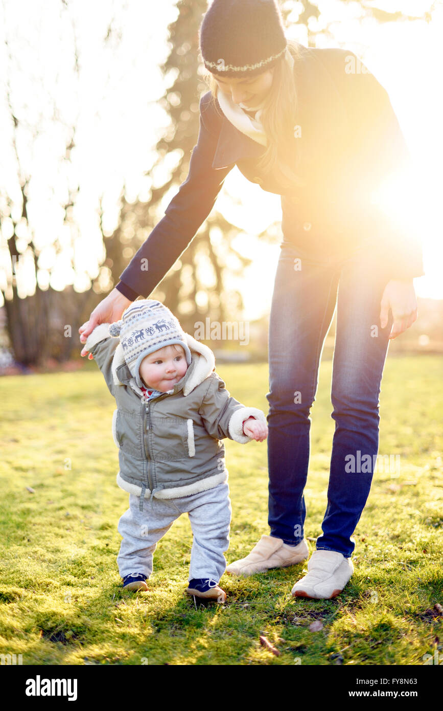 Baby girl learning to walk with help of her mother Stock Photo - Alamy