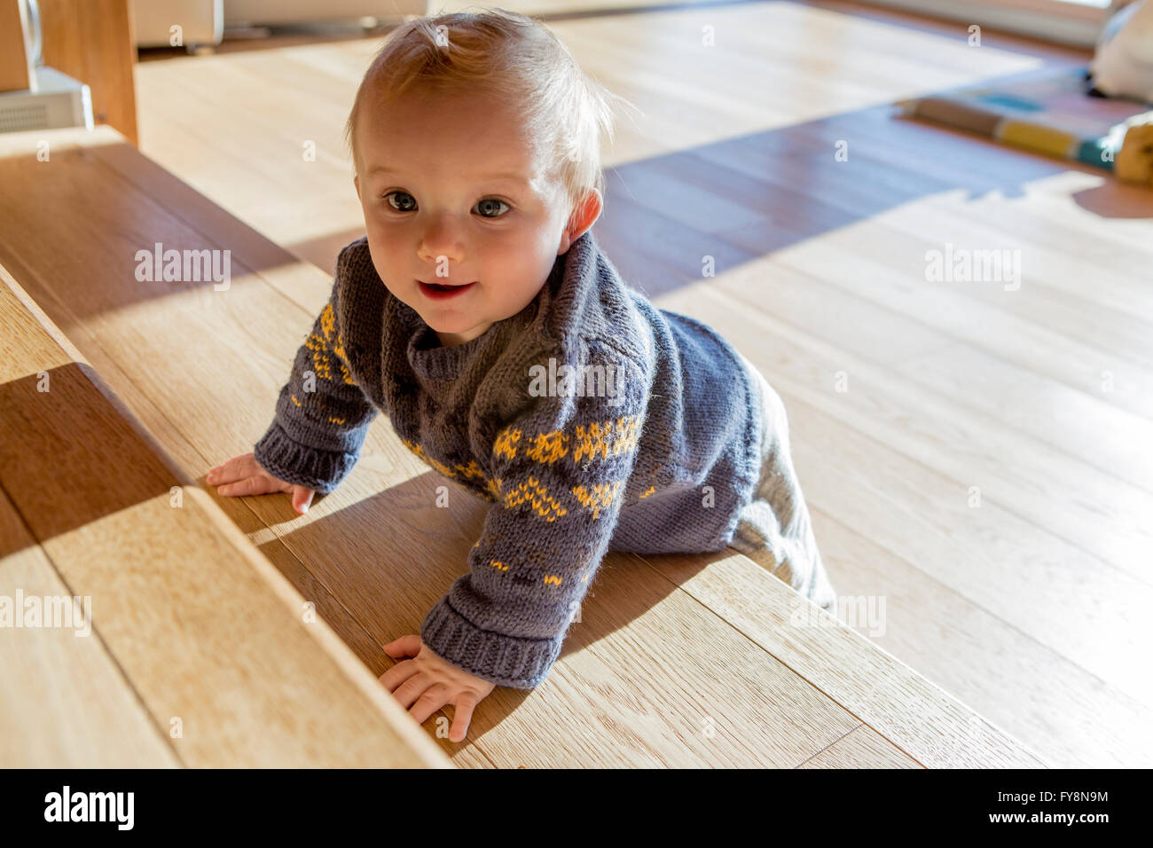 Portrait of baby boy leaning on wooden steps at home Stock Photo - Alamy