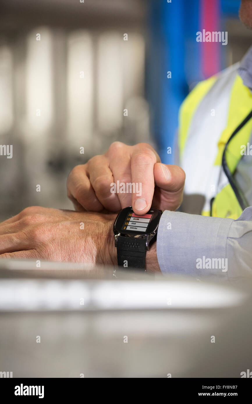 Man using smartwatch in industrial plant Stock Photo - Alamy