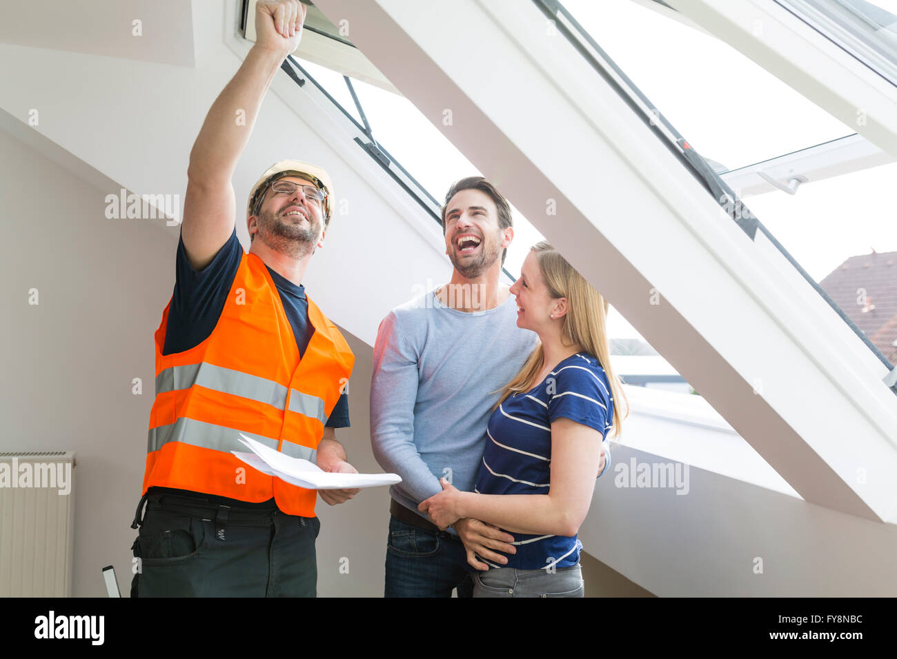 Construction worker and couple discussing rebuilding of their new home ...