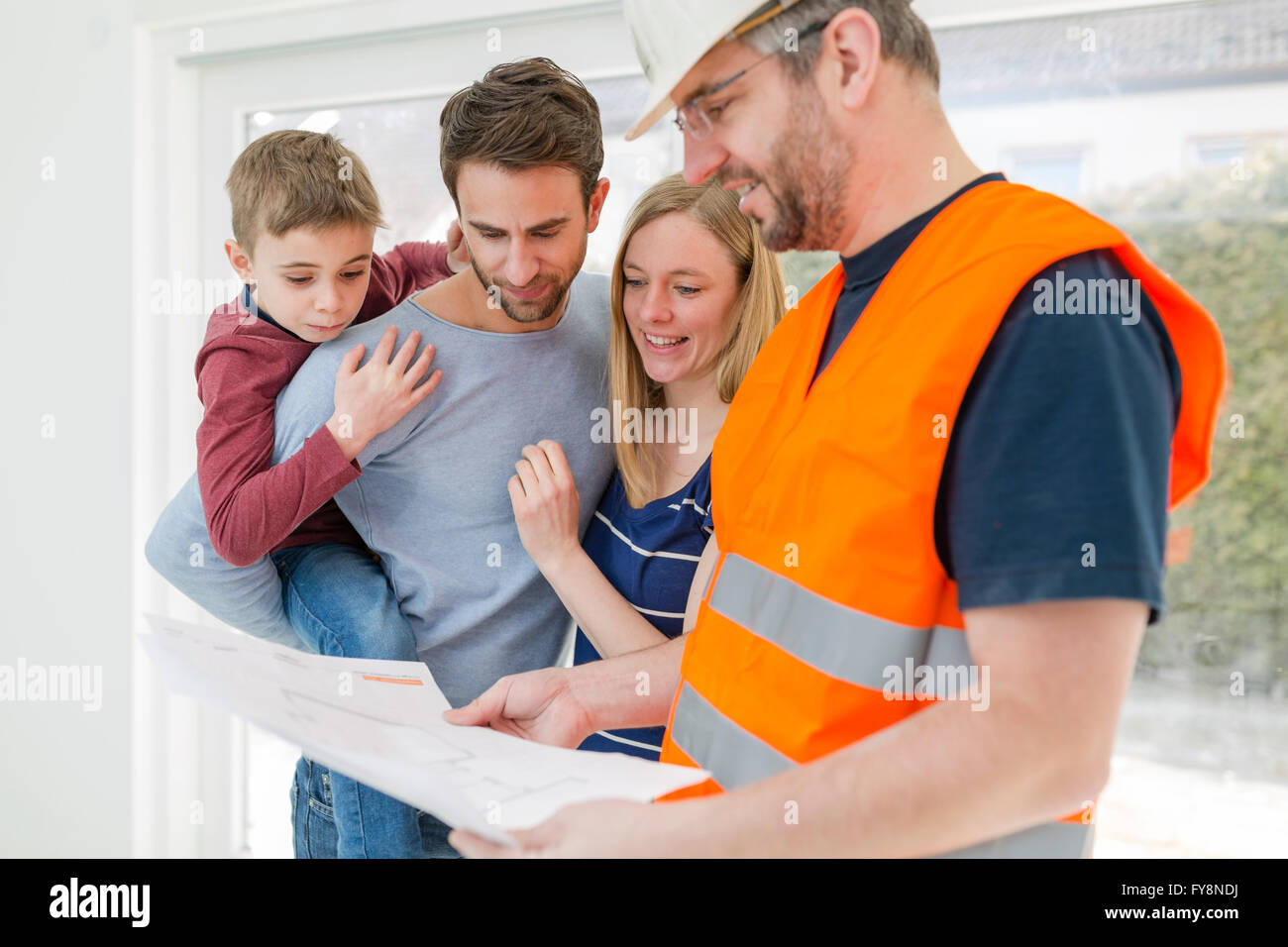 Construction worker explaining family the construction plan Stock Photo ...