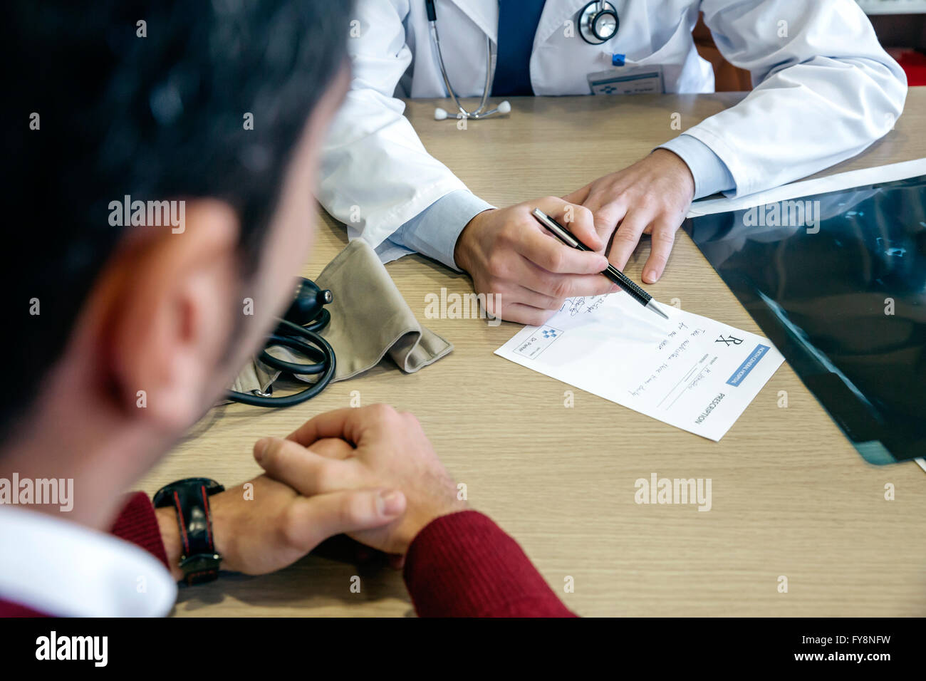 Doctor writing prescription for patient Stock Photo - Alamy