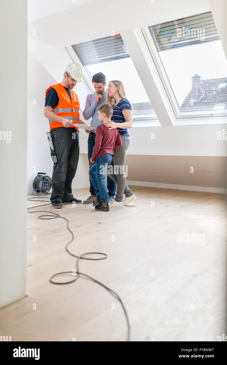 Construction worker and family discussing rebuilding of their new home ...