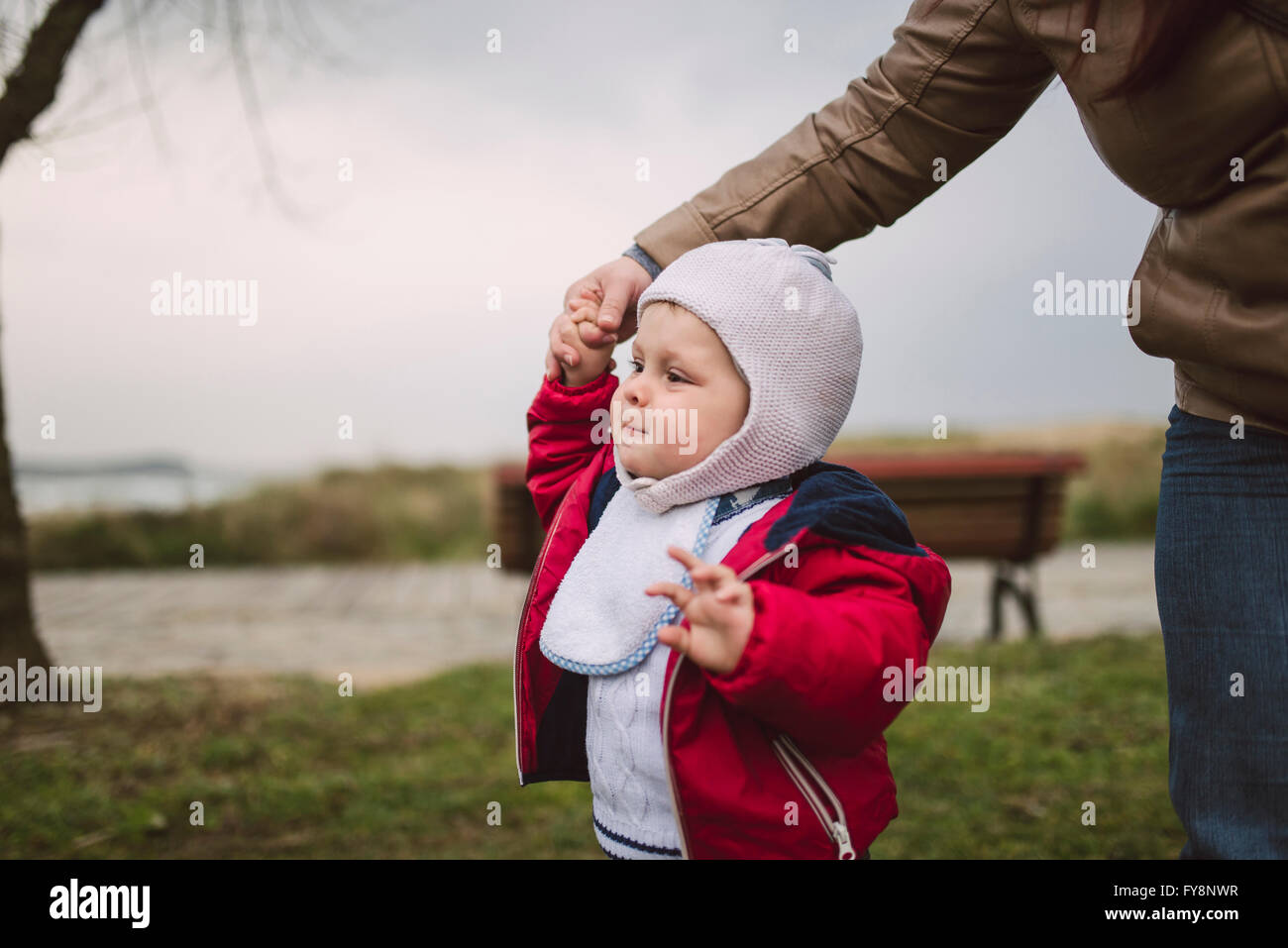 Toddler learning to walk with help of his mother Stock Photo - Alamy