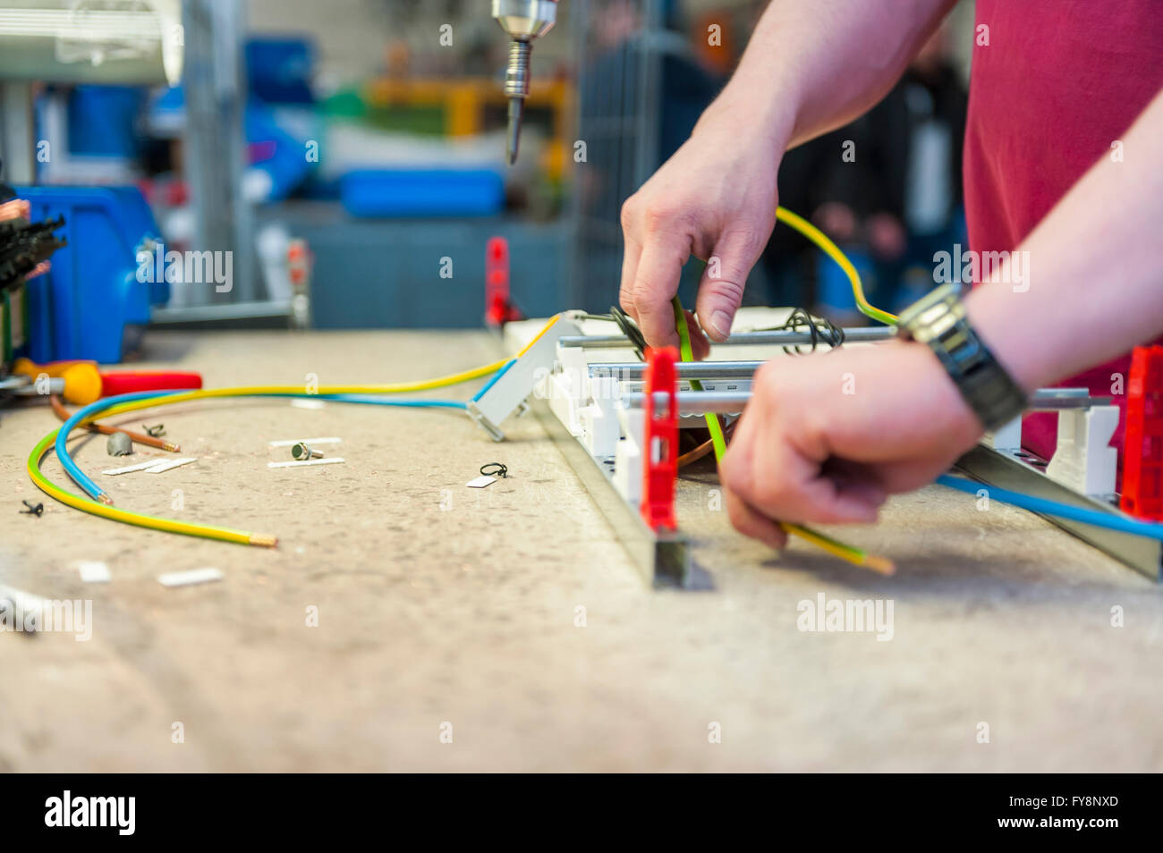 Worker cutting wires on workbench Stock Photo - Alamy