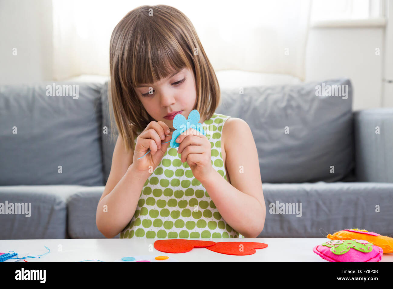 Portrait of embroidering little girl at home Stock Photo - Alamy