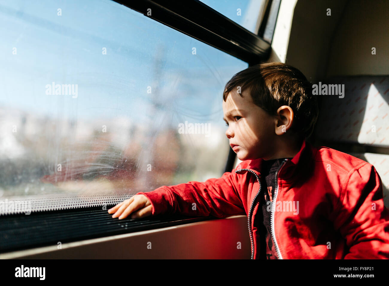 Little boy on his first train ride looking through the window Stock ...