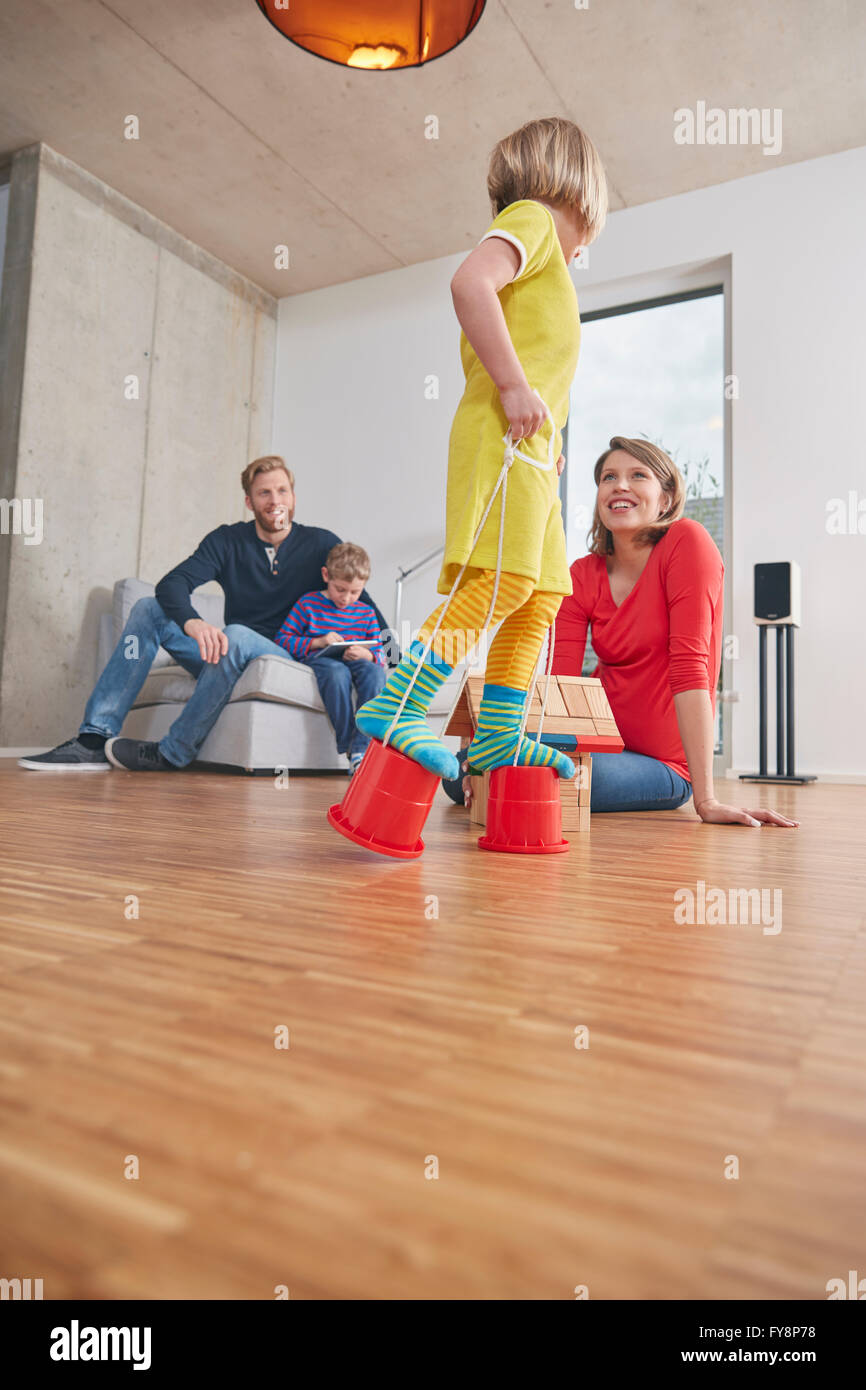 Family at home with daughter walking on buckets Stock Photo - Alamy