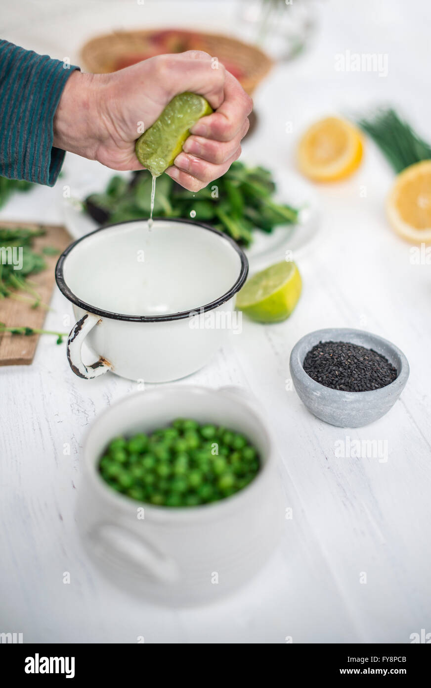 Hand squeezing a lime preparing a salad Stock Photo - Alamy