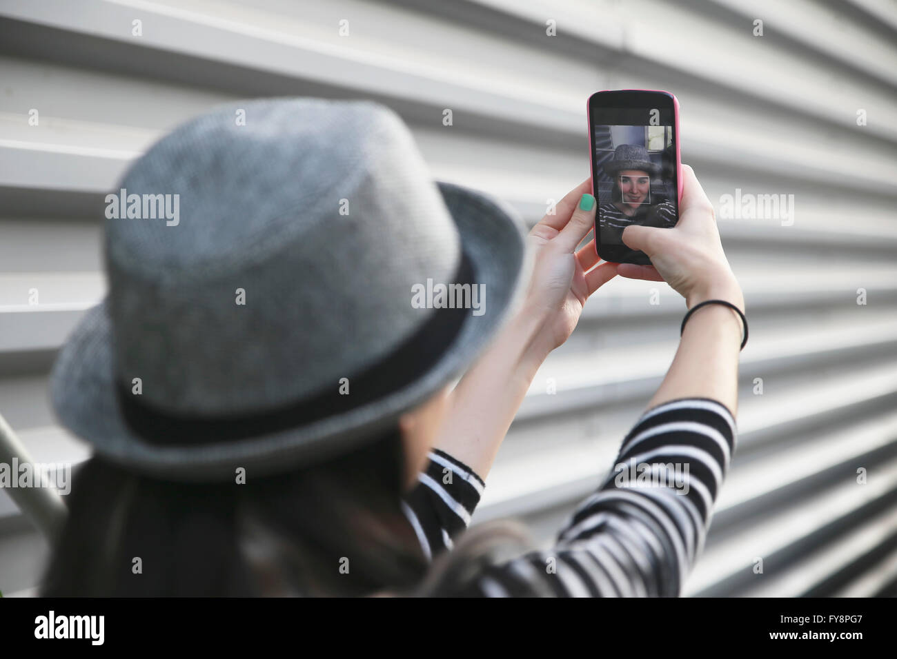 Back view of young woman taking a selfie with smartphone Stock Photo ...