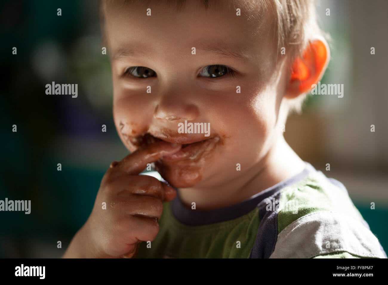 Smiling little boy eating chocolate Stock Photo - Alamy