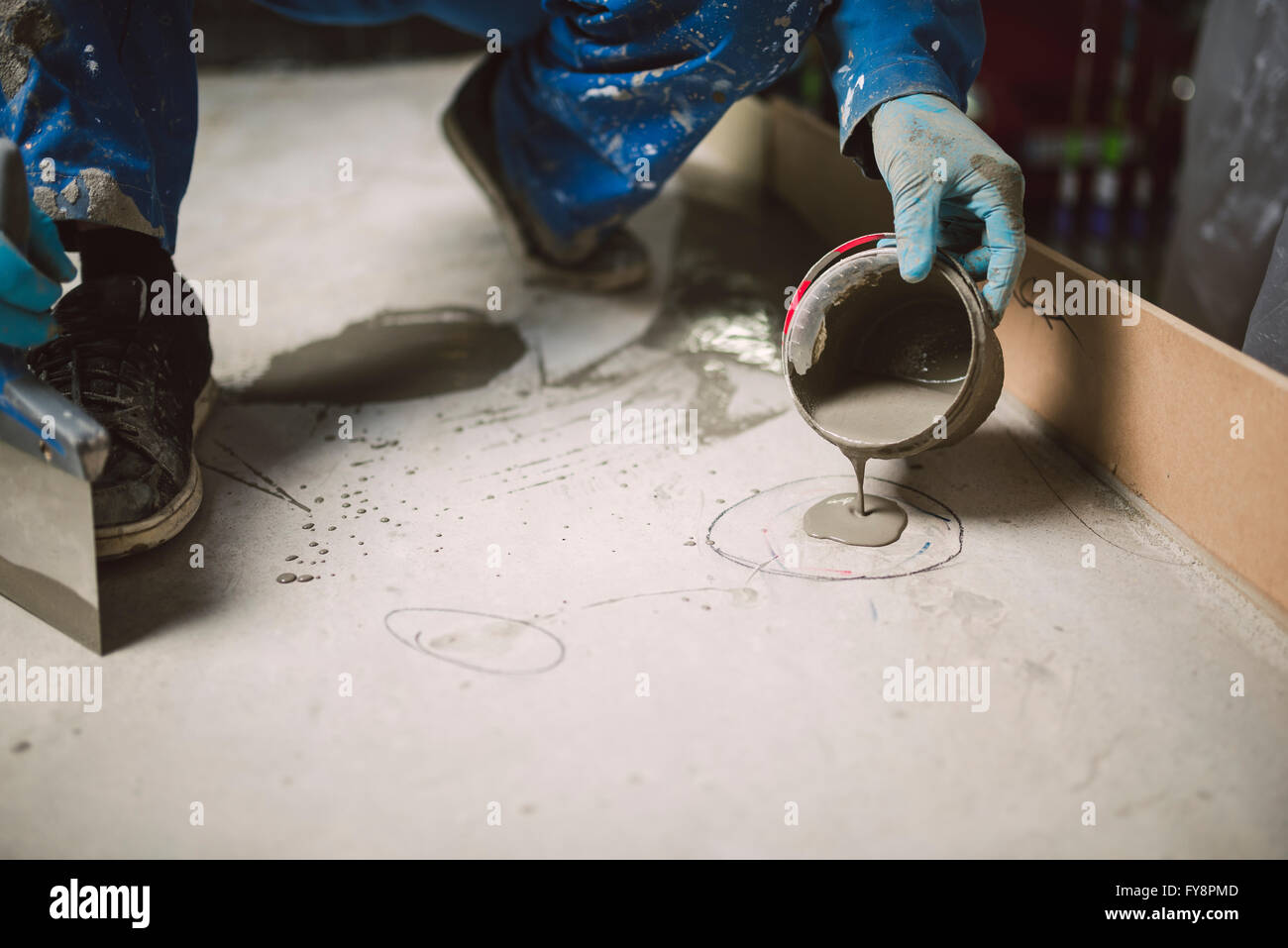 Bricklayer applying wet cement on floor Stock Photo - Alamy