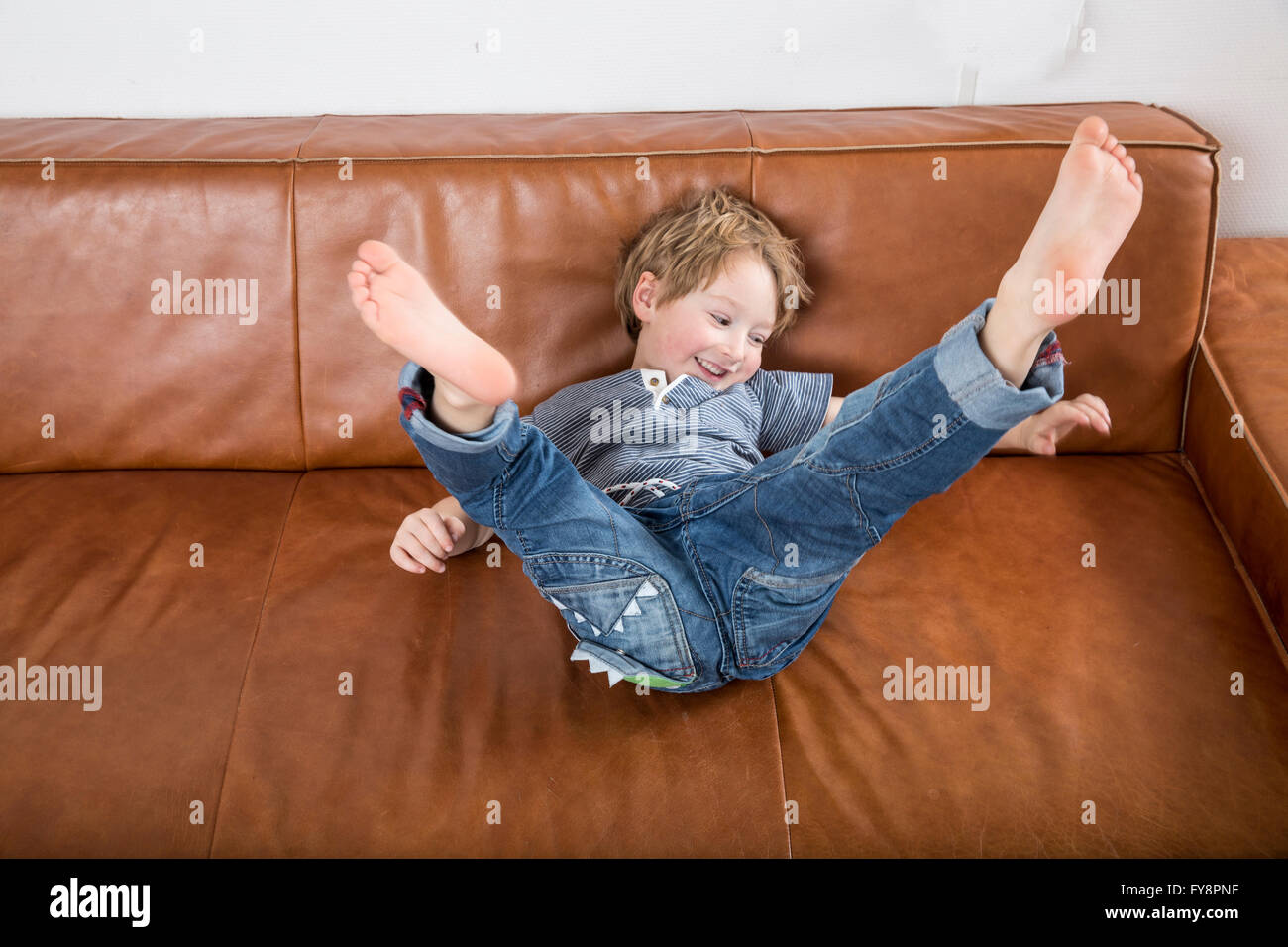 Boy messing around on couch Stock Photo - Alamy