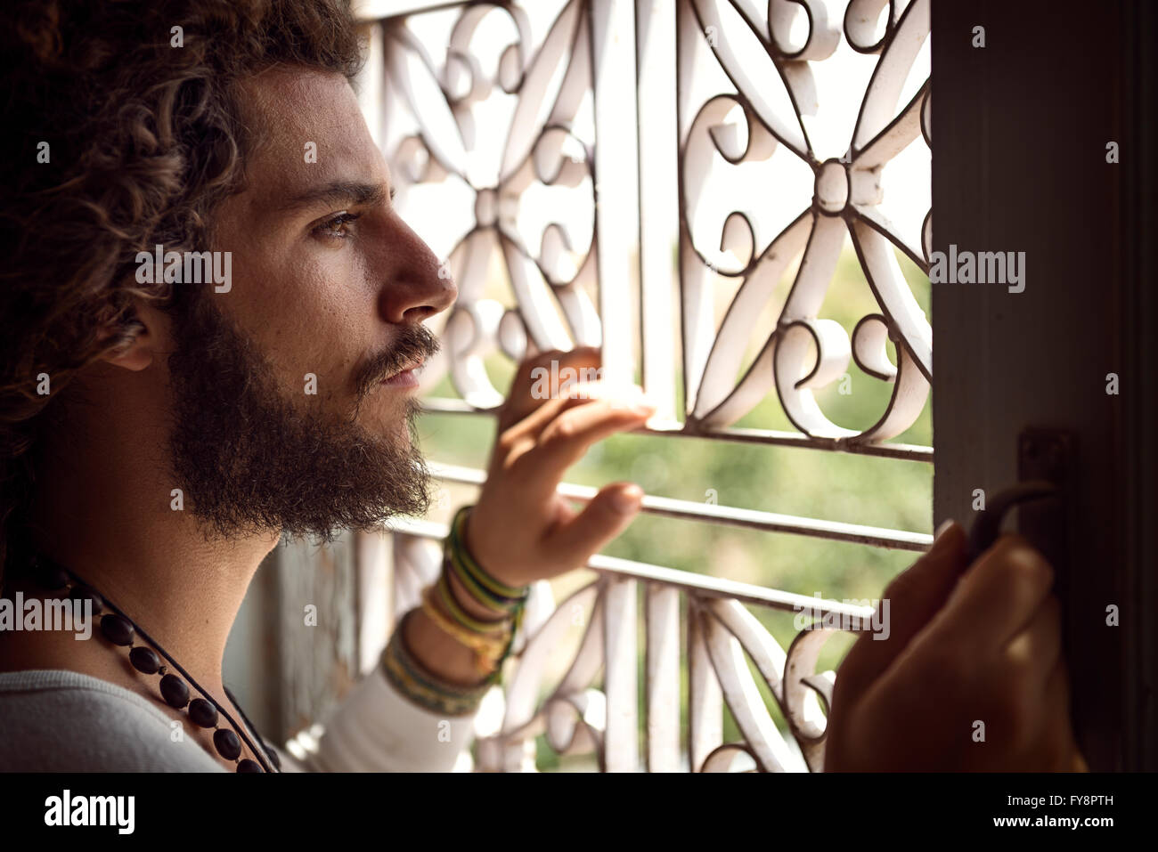 Man standing at window, looking out Stock Photo - Alamy