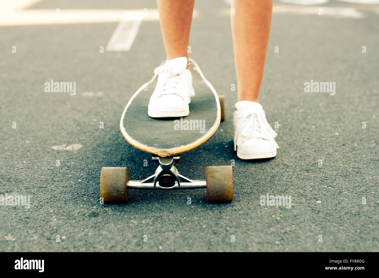 Legs of teenage girl with longboard Stock Photo - Alamy
