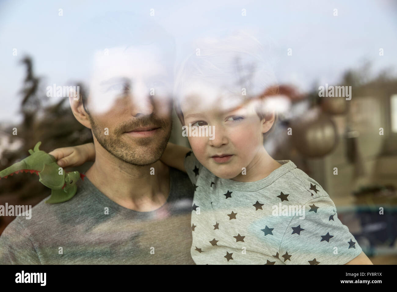 Father and son looking out of window Stock Photo - Alamy