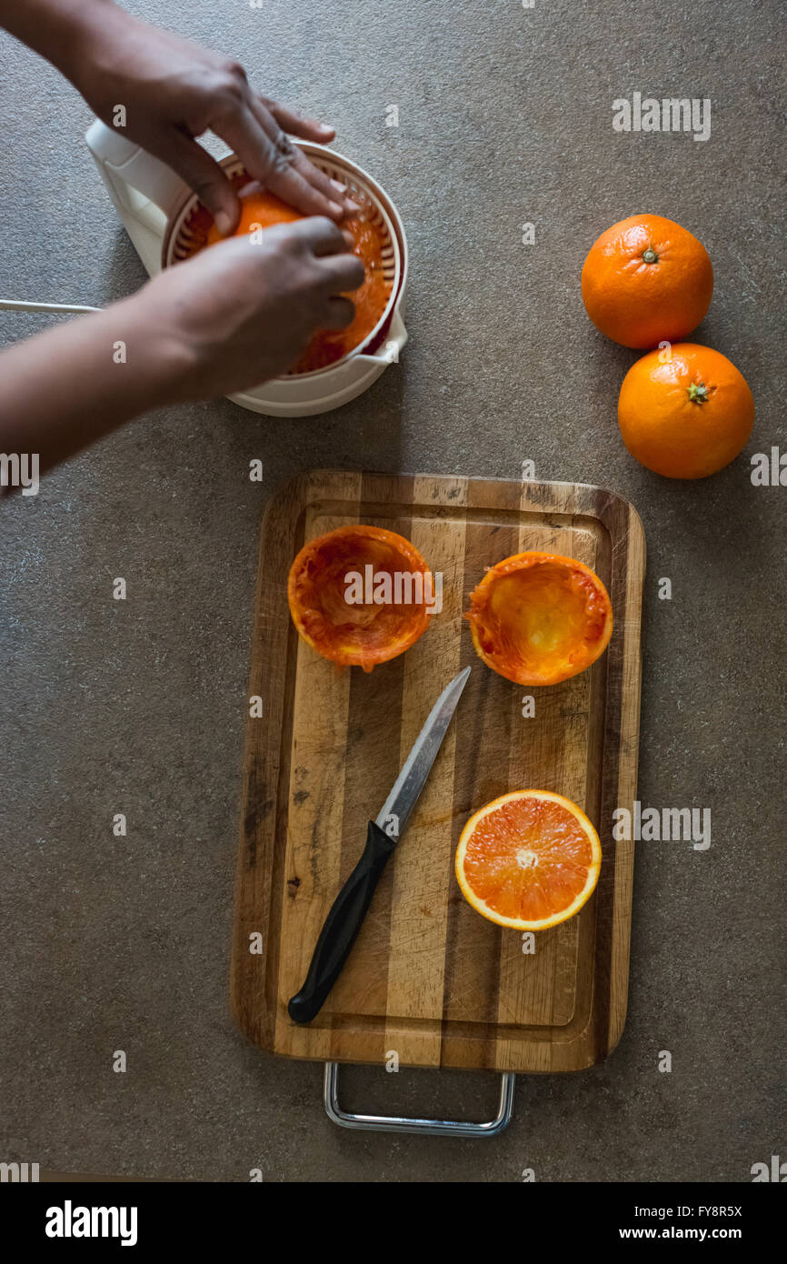 Young woman squeezing orange juice Stock Photo - Alamy