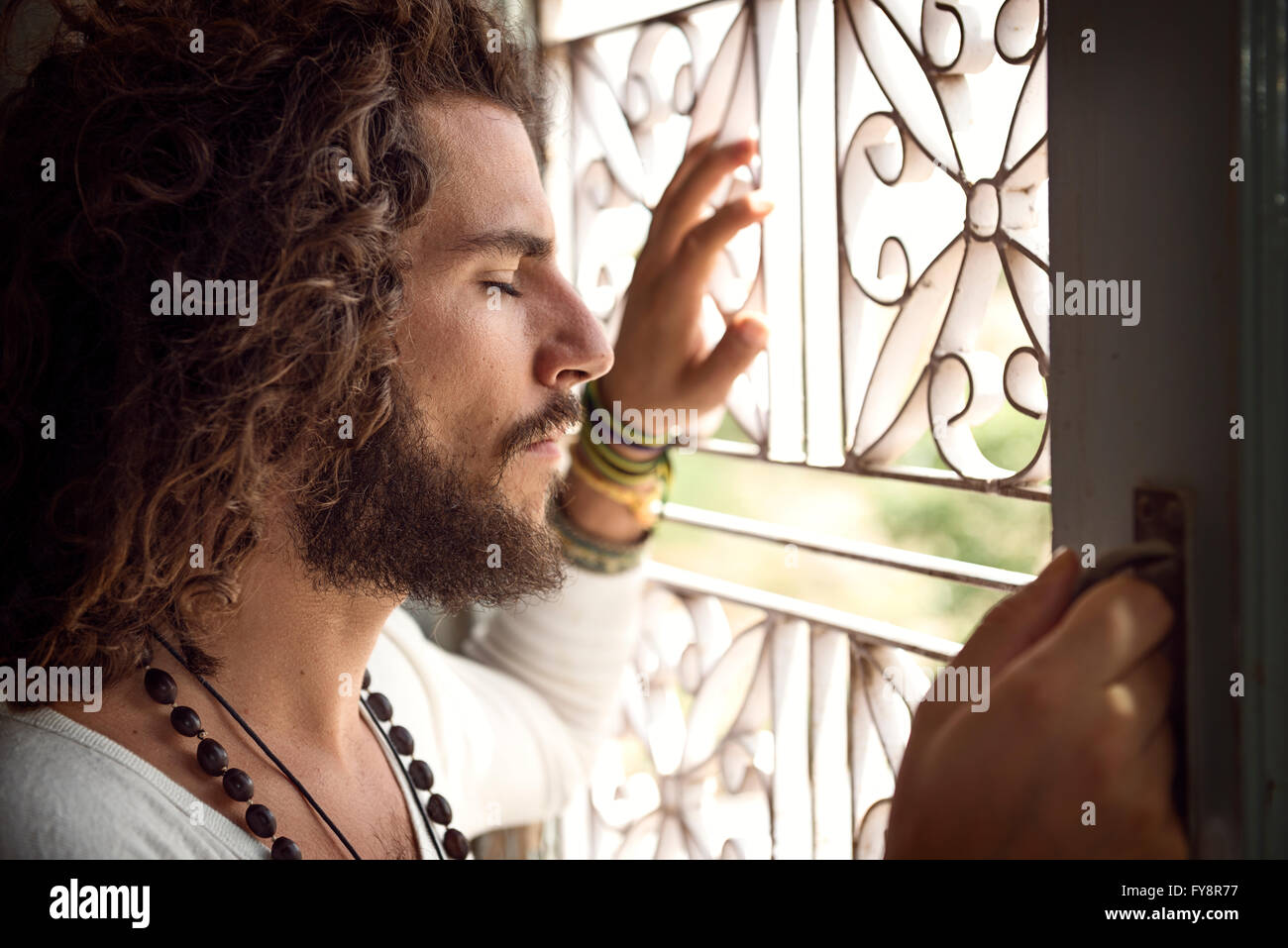 Man standing at window with closed eyes Stock Photo - Alamy