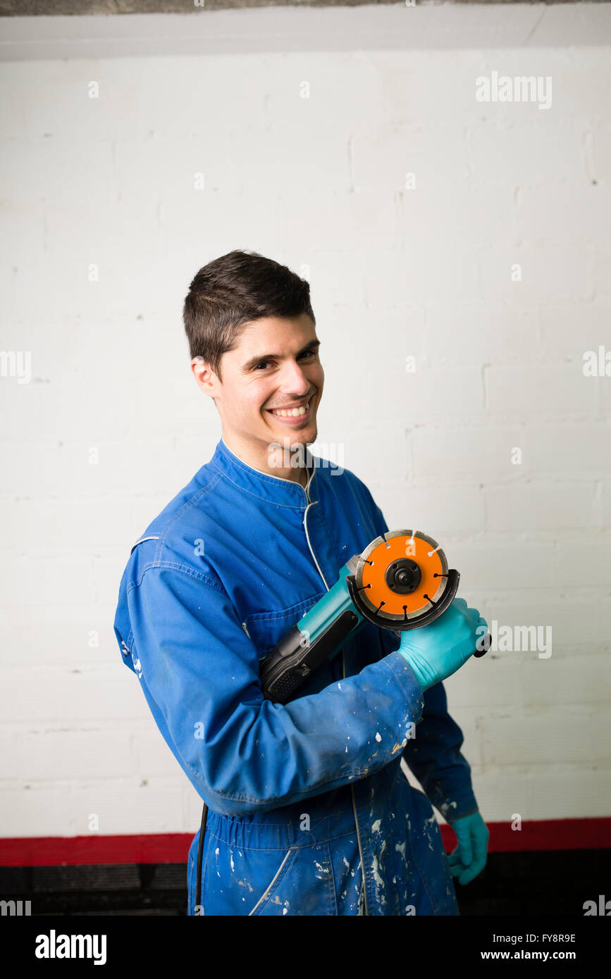 Portrait of smiling construction worker holding an angle grinder Stock ...