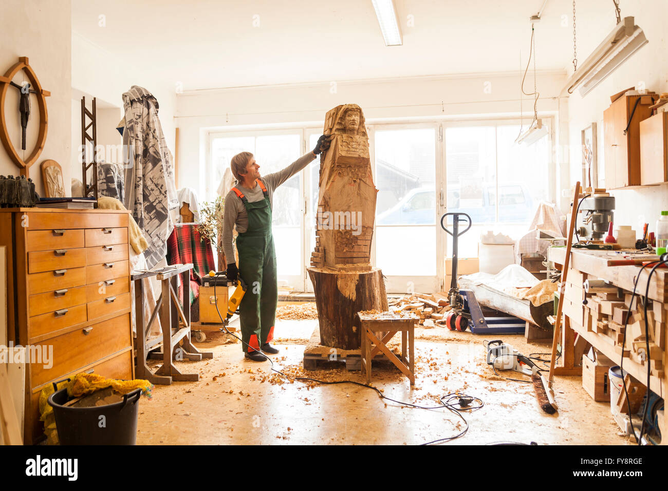 Wood carver in workshop working on sculpture Stock Photo - Alamy