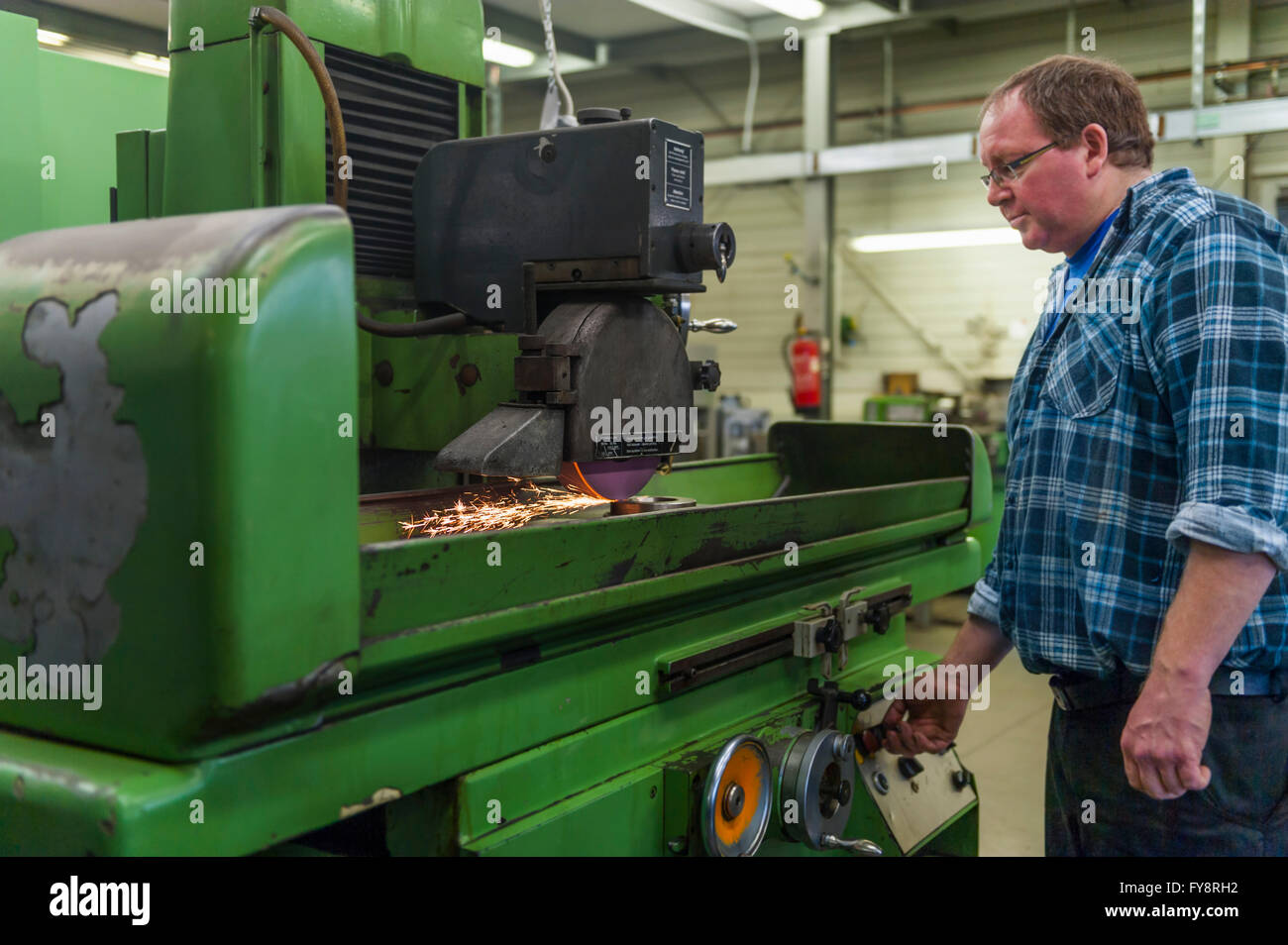 Man operating grinding machine Stock Photo - Alamy