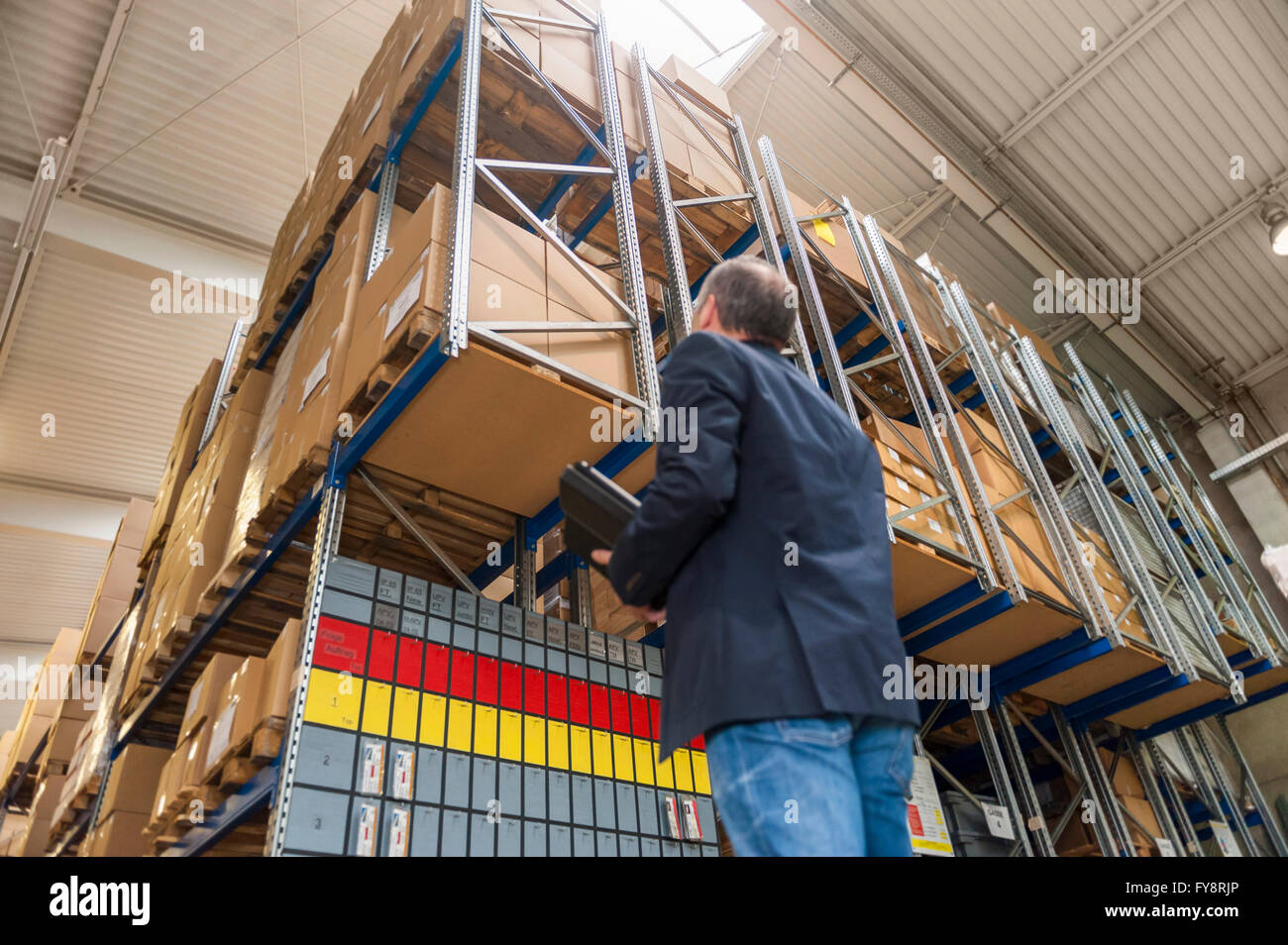 Manager checking goods in storage hall of factory Stock Photo - Alamy