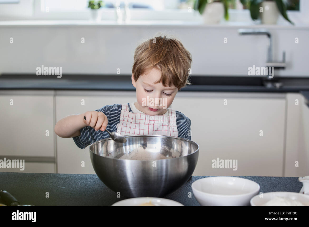 Little boy helping to prepare food in the kitchen Stock Photo - Alamy