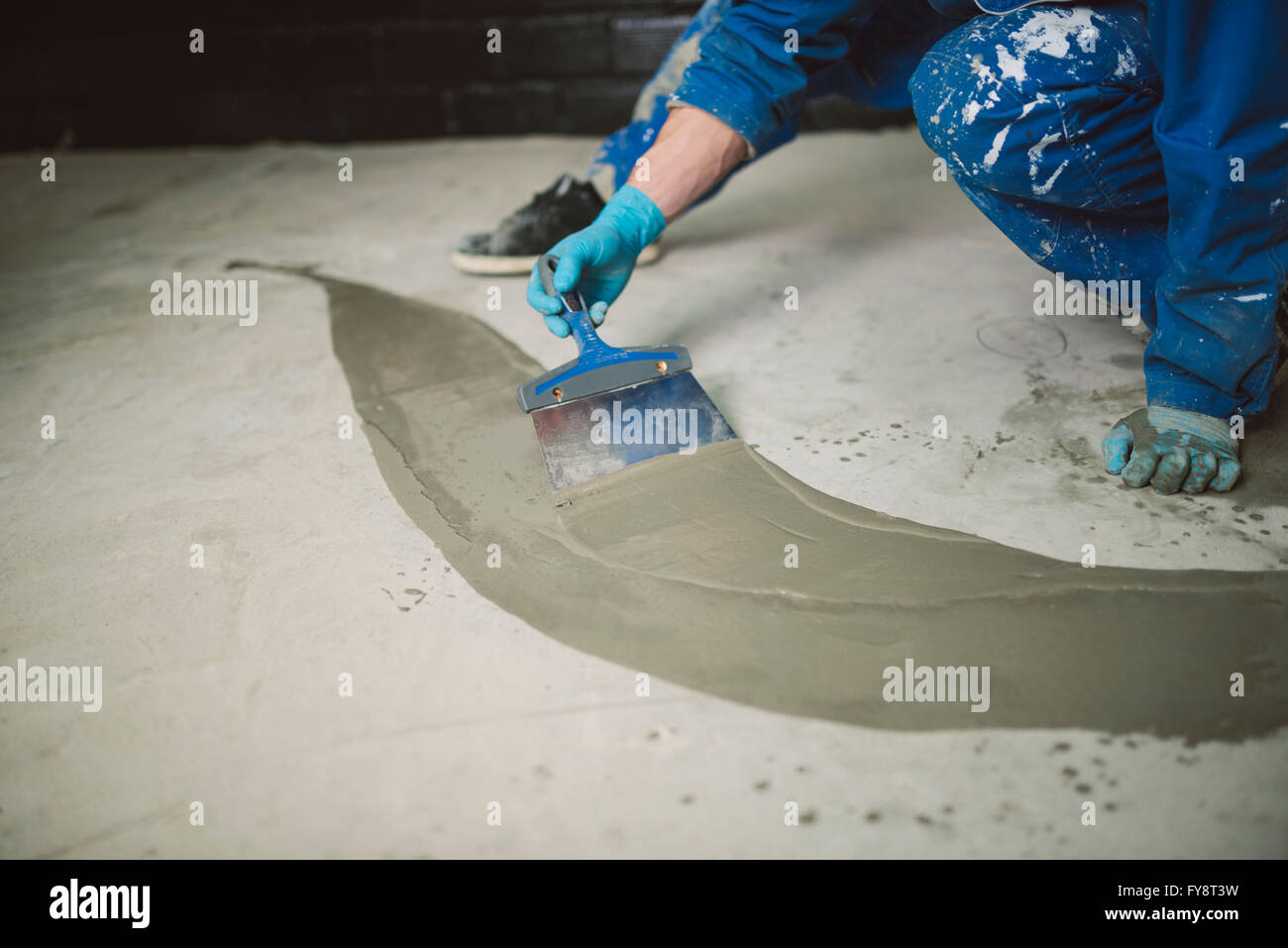 Bricklayer applying wet cement on floor Stock Photo - Alamy