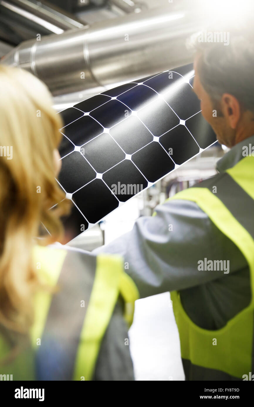 Colleagues wearing reflective vests examining innovative solar panel Stock Photo - Alamy