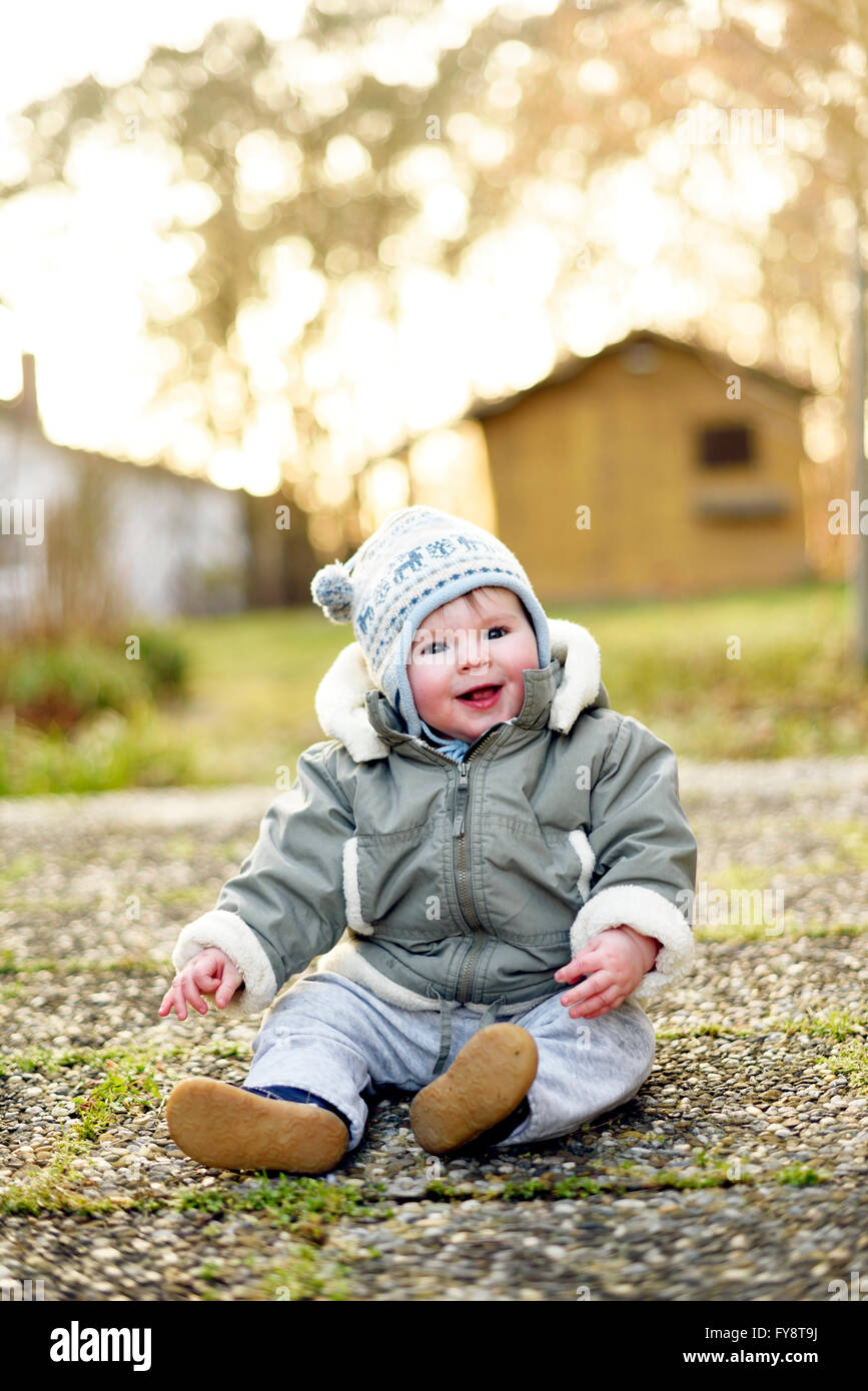 Portrait of smiling baby girl sitting on slabs Stock Photo - Alamy