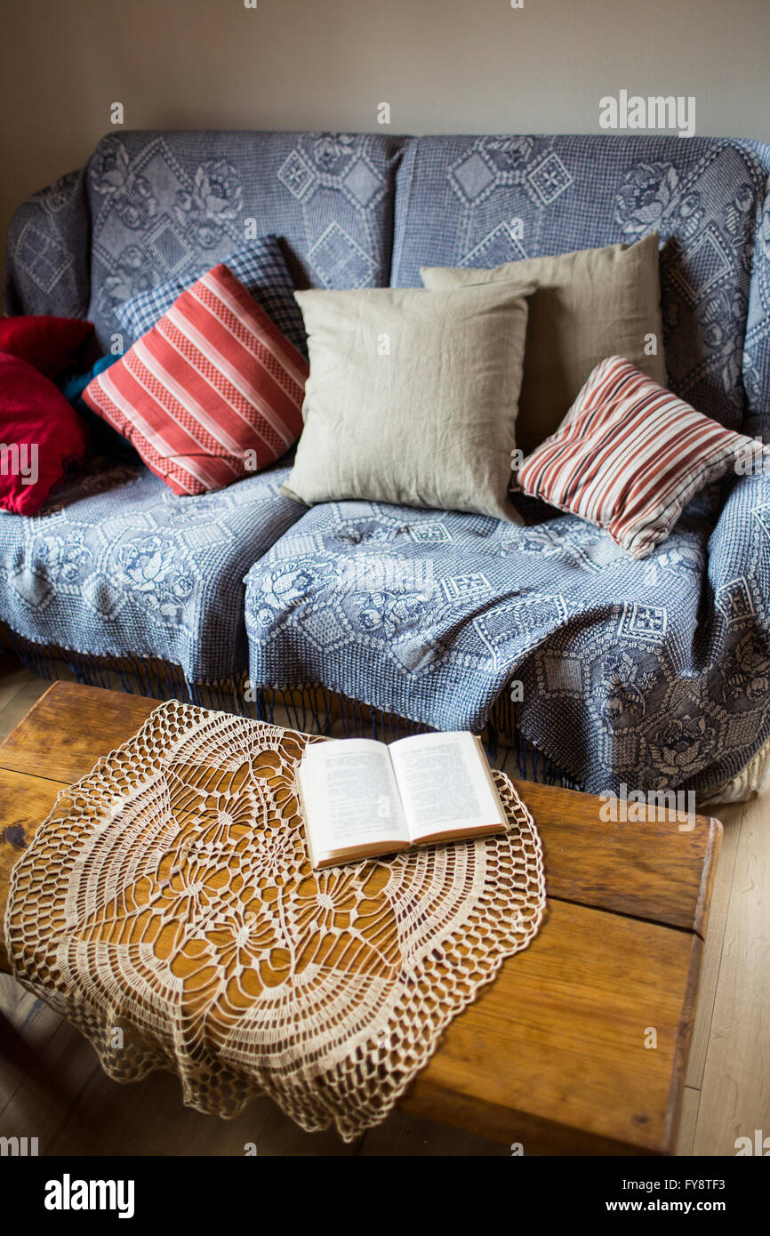 Couch with cushions and doily on coffee table Stock Photo - Alamy