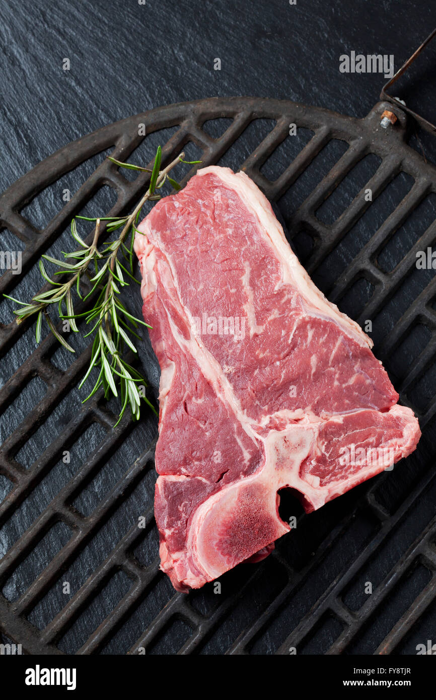 Raw porterhouse steak with rosmary on grill Stock Photo - Alamy