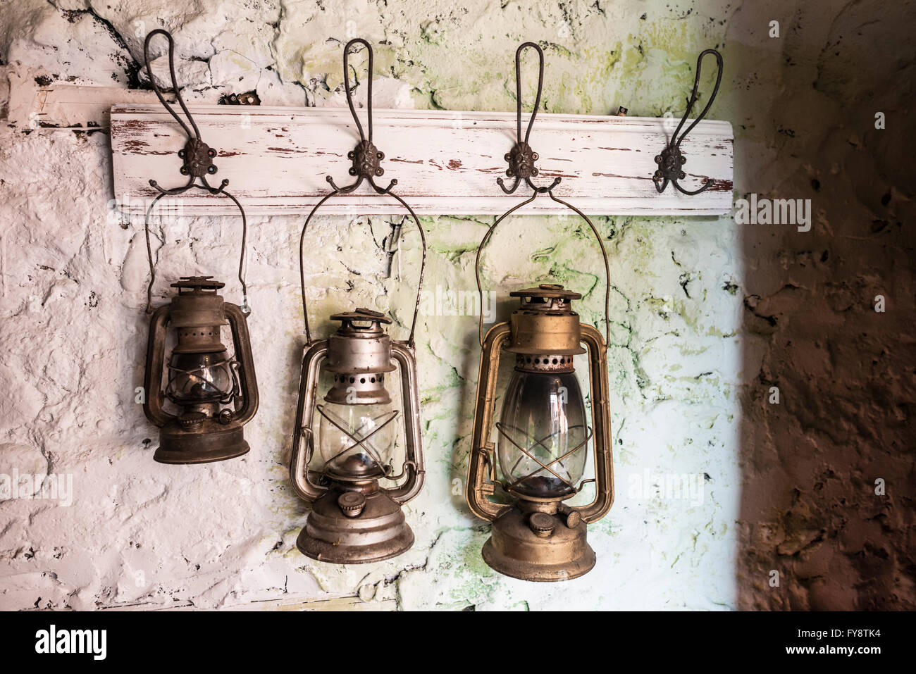 Old vintage storm lamps on painted stone wall Stock Photo - Alamy