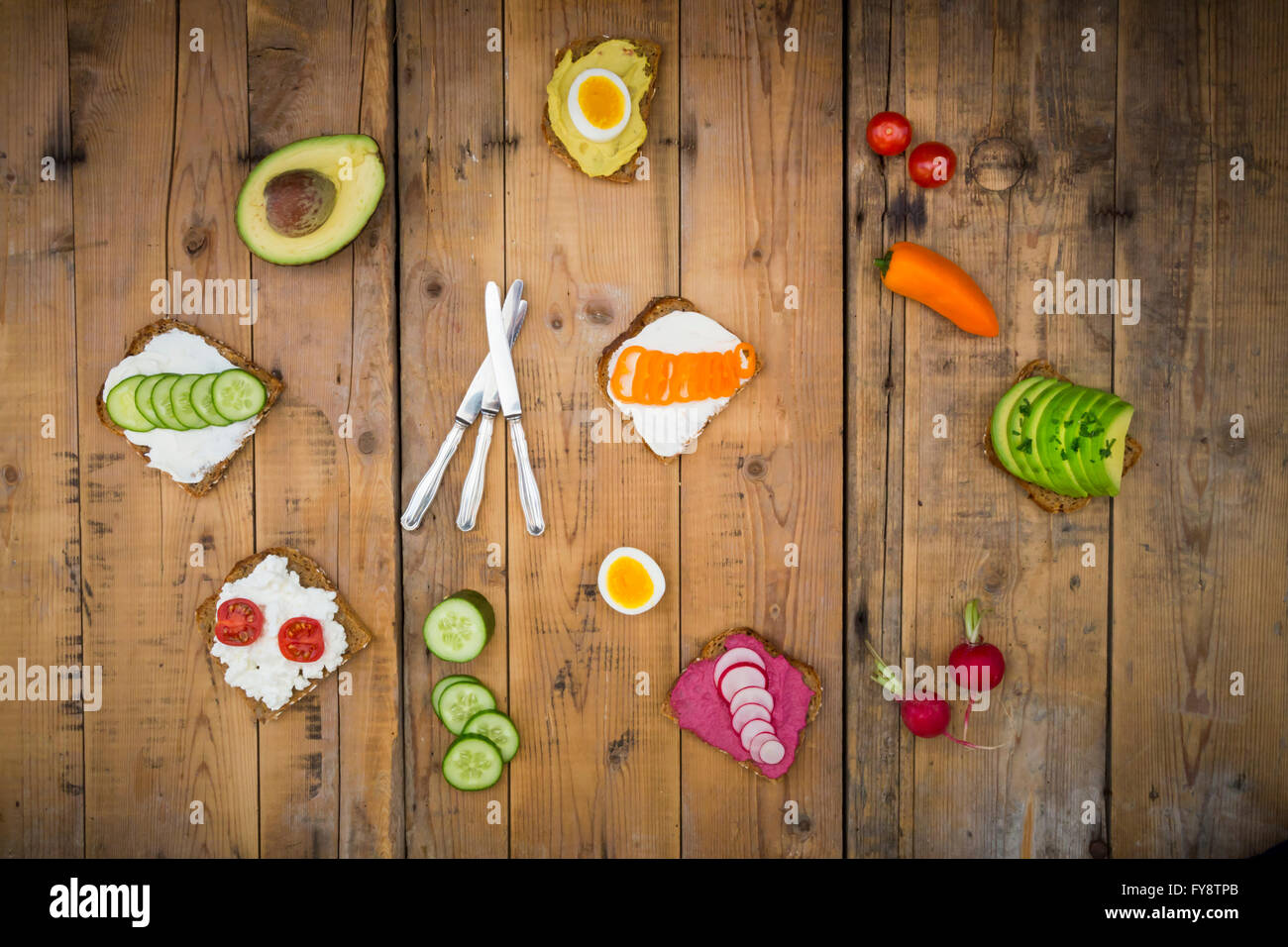 Wholemeal bread slices with different spreads and toppings on wood ...
