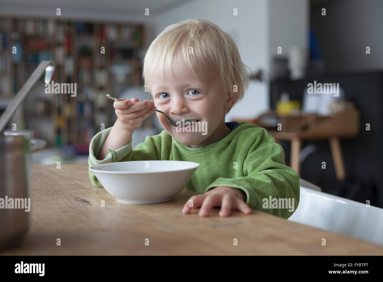 Portrait of smiling little boy eating soup at home Stock Photo - Alamy