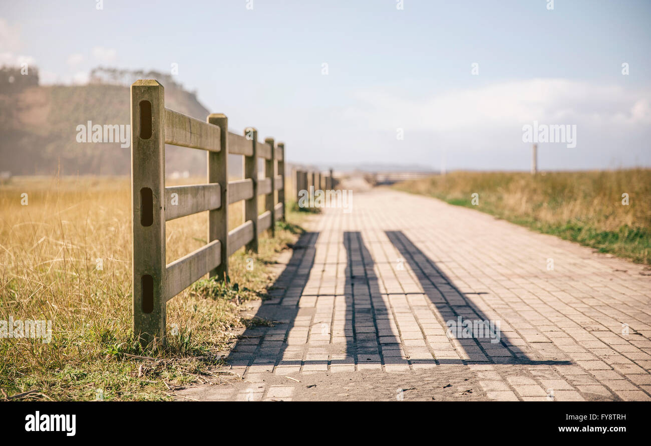 Spain, Asturias, Wooden fence and the shadow over a empty promenade ...