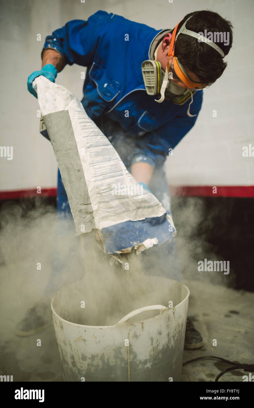 Bricklayer pouring cement powder in bucket Stock Photo - Alamy