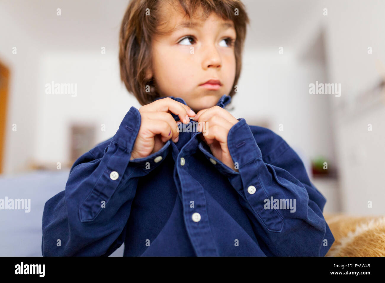Little boy buttoning his shirt Stock Photo - Alamy