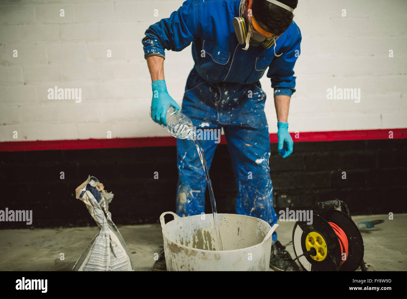 Person mixing cement in bucket hi-res stock photography and images - Alamy