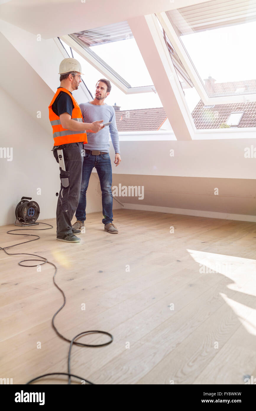 Construction worker discussing with building owner rebuilding of the ...