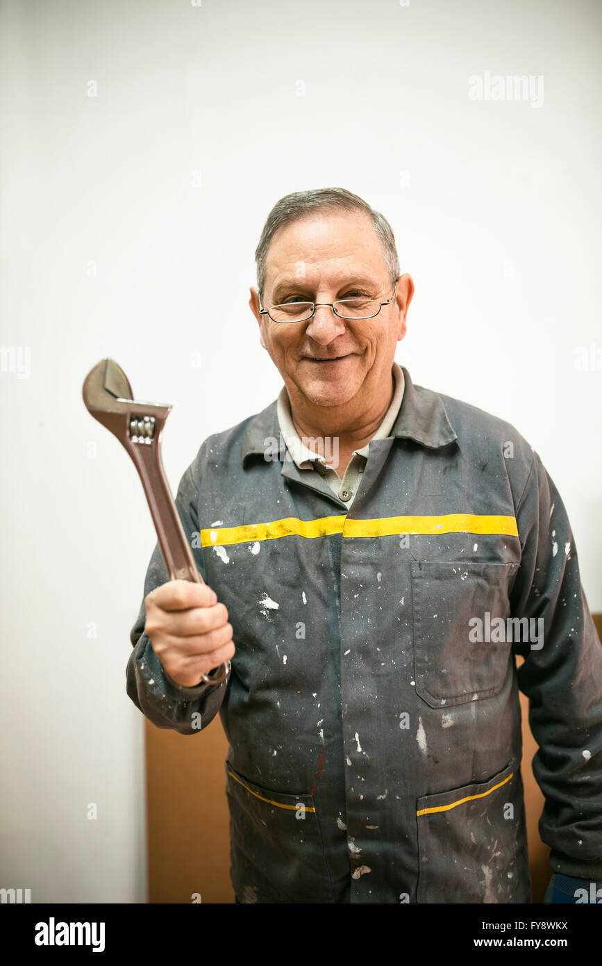 Portrait of smiling senior man holding tool Stock Photo - Alamy