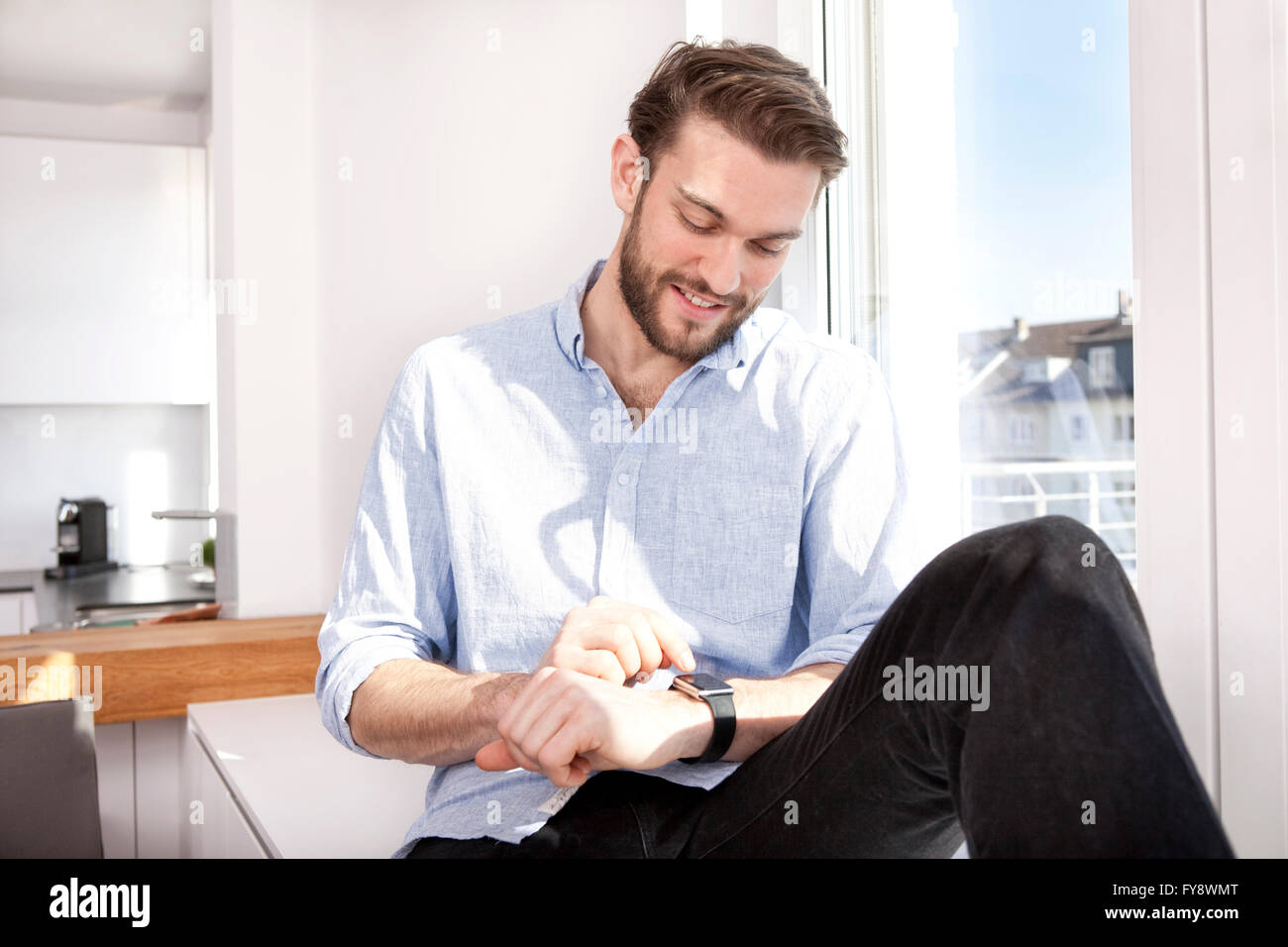 Young man using smartwatch at home Stock Photo - Alamy